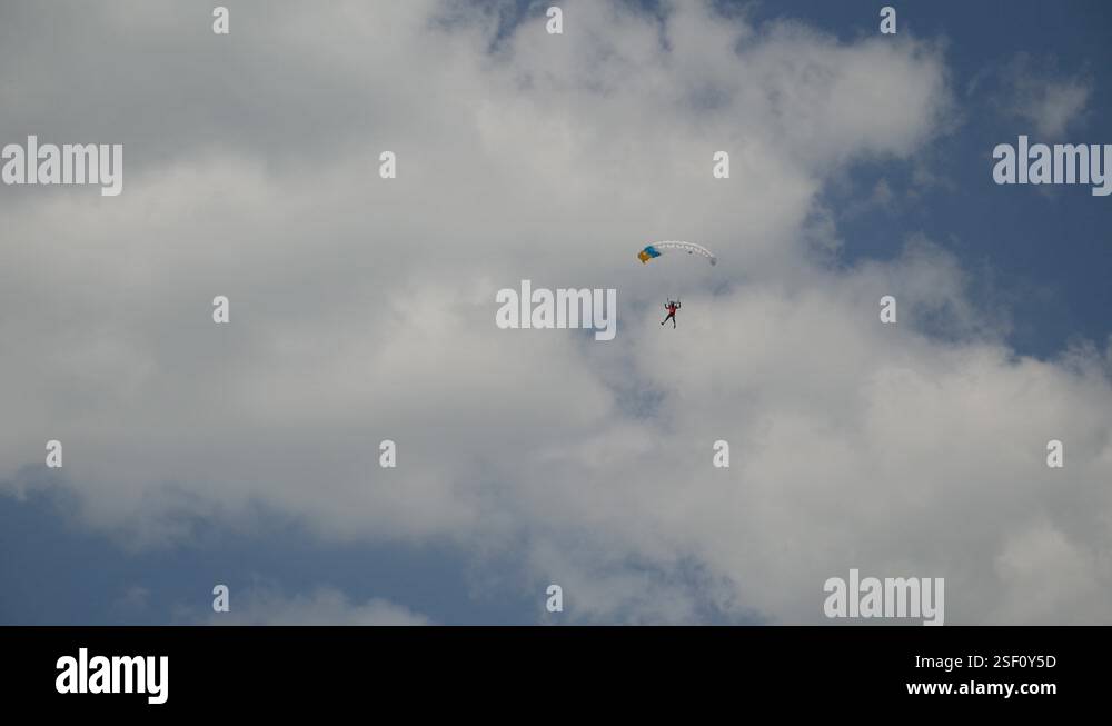 Rear view of a parachutist circling in the air with a wing parachute ...