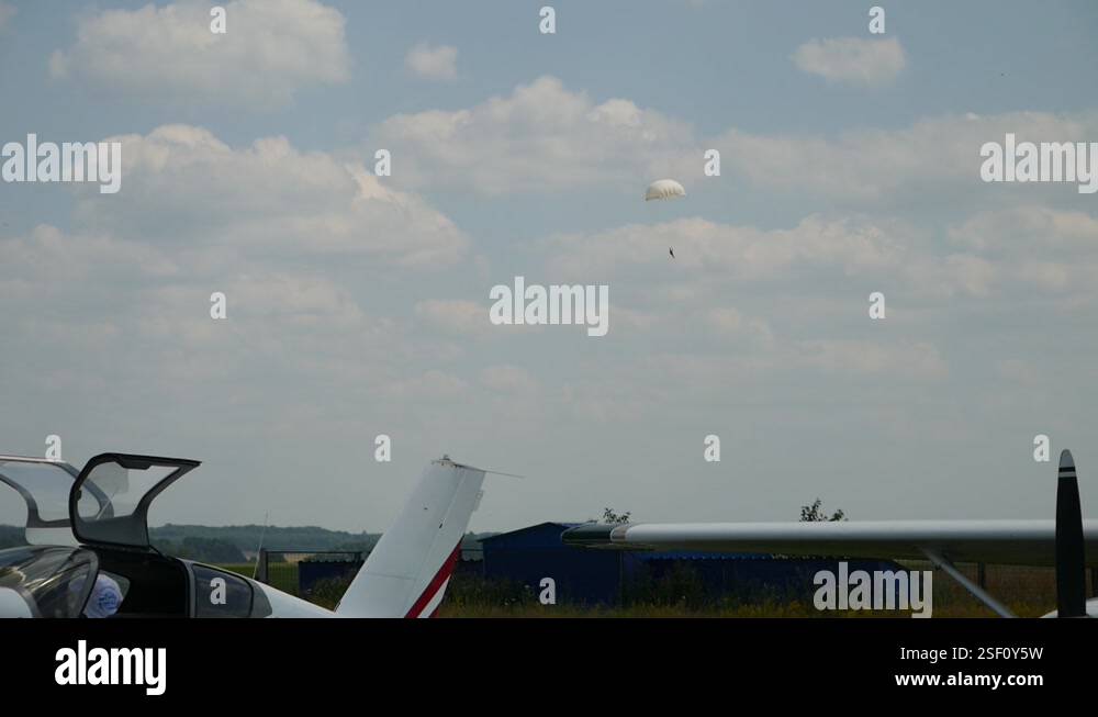 Rear view of a parachutist circling in the air with a wing parachute ...