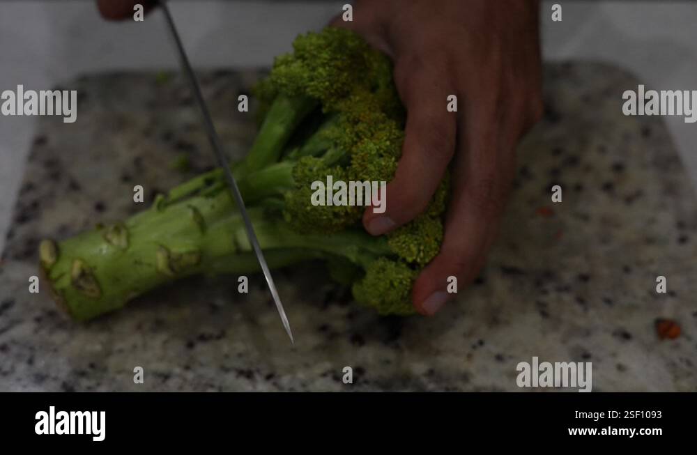 person cutting a broccoli with knife on chopping board Stock Video ...