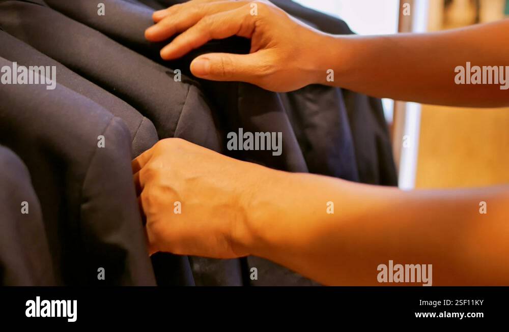 Female hands choosing suit jacket on hanger in department store Stock ...