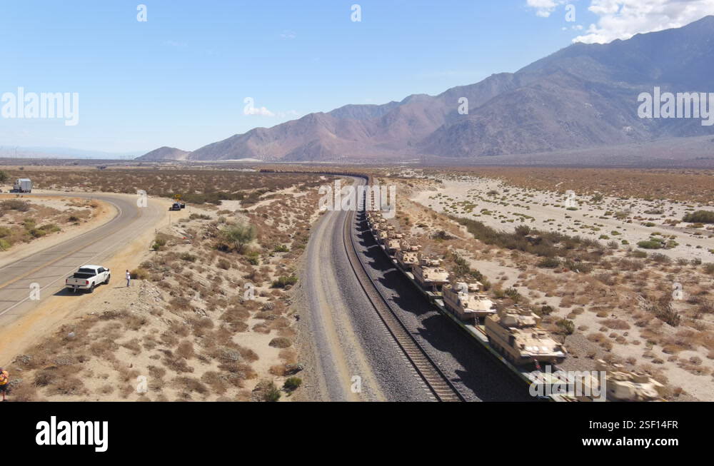Army train transporting military vehicles and tanks by rail through the ...