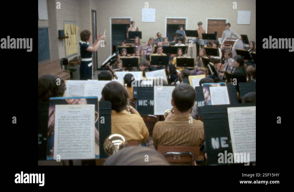 1970s: Woman at front of classroom conducts a student orchestra Stock ...
