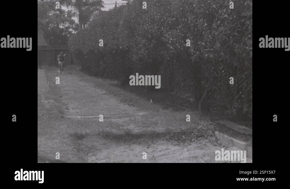 1960s: Man runs in dash, does long jump at marker, lands in sand pit ...