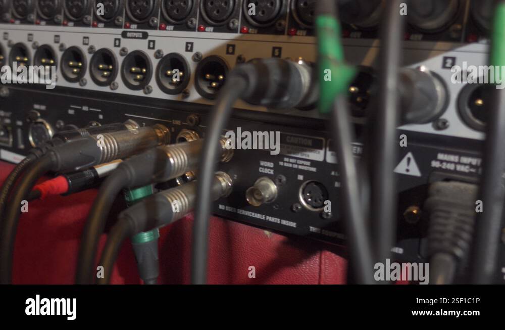 A Panning Shot of the Backside of a Music Mixer with lots of Plugs and ...