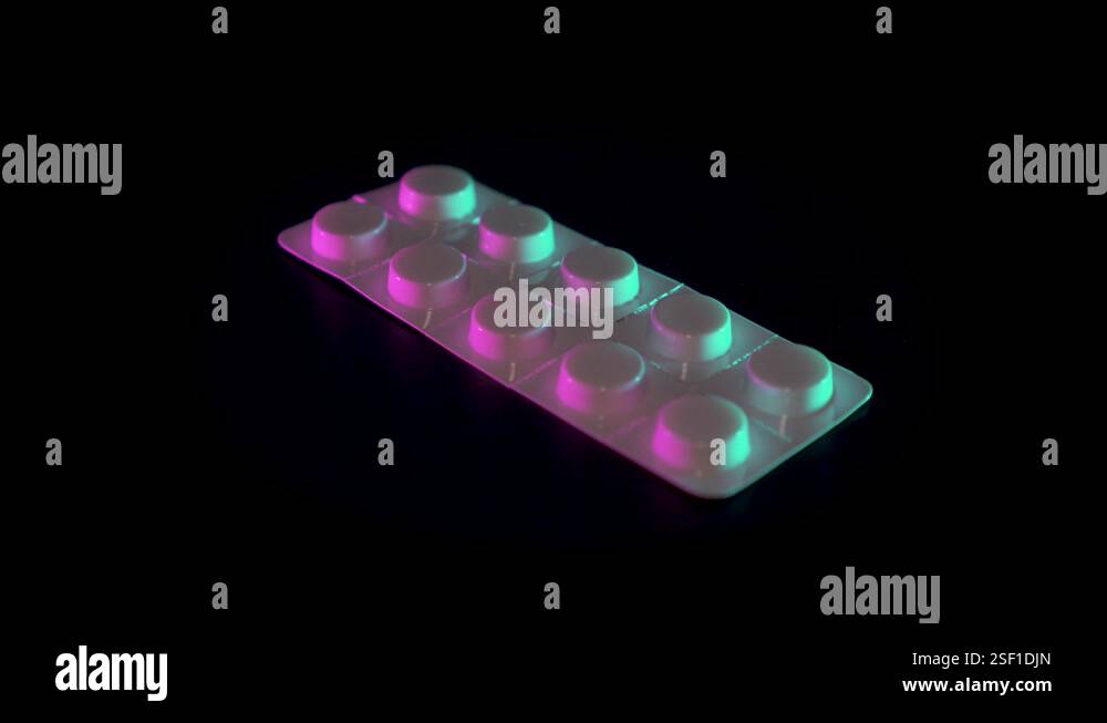 A strip of paracetamol rotating (loopable). Purple and green light ...