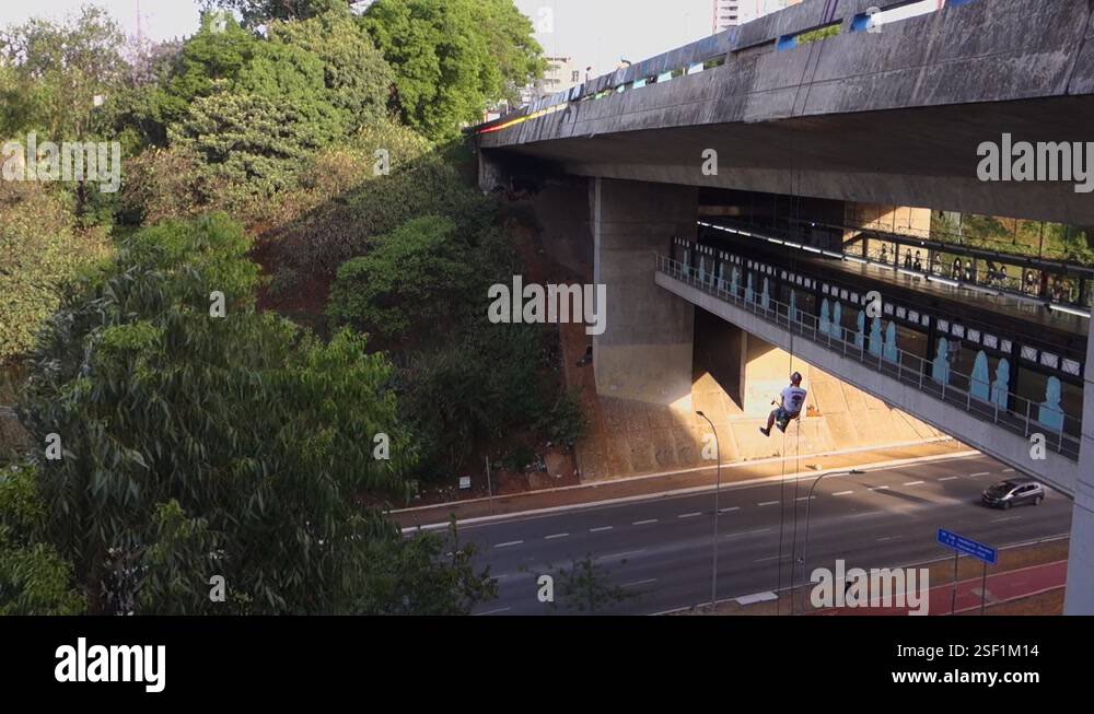 man abseiling on the viaduct and hanging on the rope. extreme sports in ...