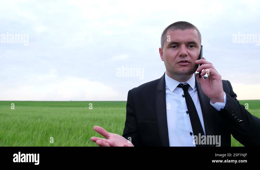 An angry businessman is talking on a smartphone, he got into trouble in ...
