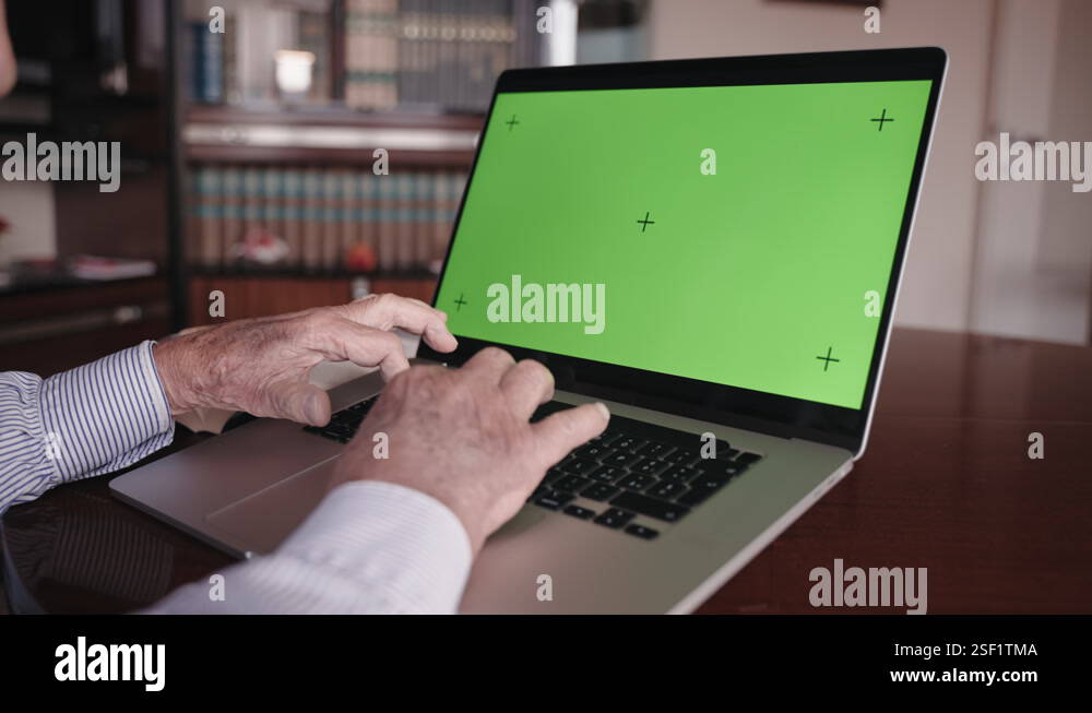 Wrinkled hands of senior professor tying on computer keyboard with ...