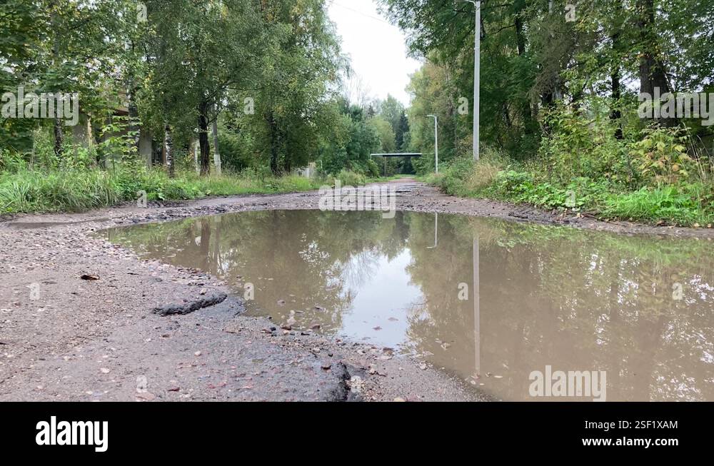 Huge puddles on country road. Water obstacles on road in countryside ...