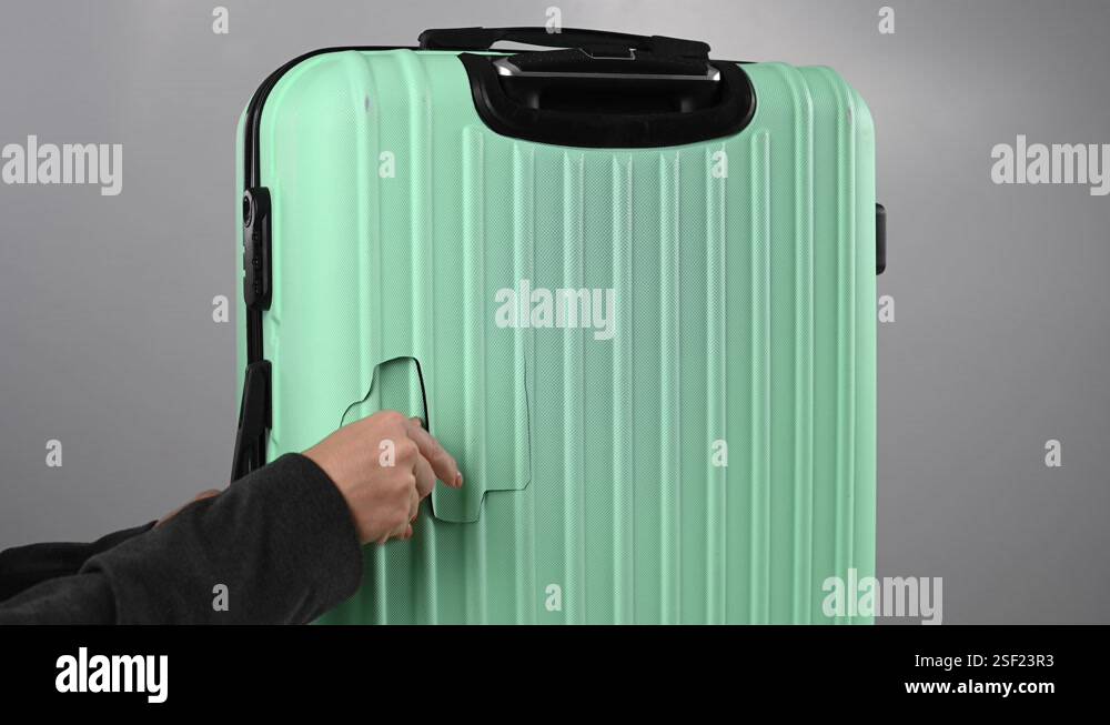 A woman demonstrates a broken suitcase on a white background. Damaged ...