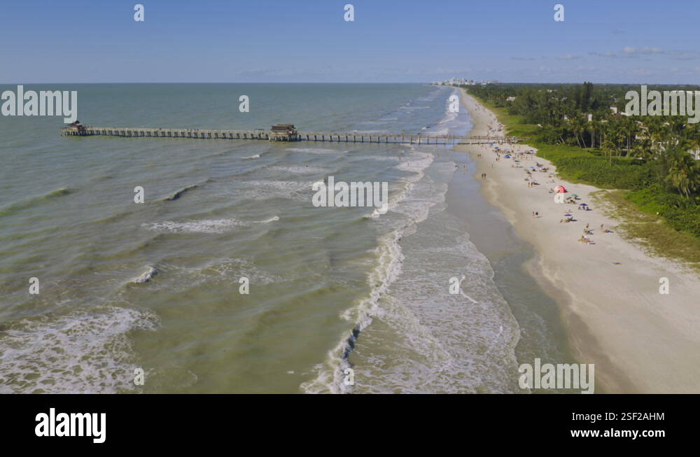 Naples Beach aerial with Naples Pier fly away Stock Video Footage - Alamy