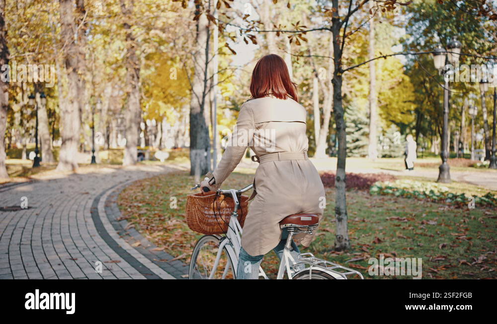 Back View Of Unknown Redhead Female Riding Her Cruiser Bike By Tiled Path Of Stock Video Footage