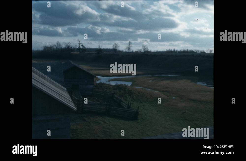1960s: Farm. Barn with pen. Woman works with fabric. Tools lean on wall ...