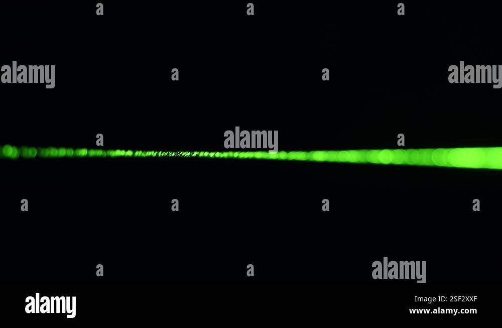 Dust particles in green laser light beam from diffraction grating Stock ...