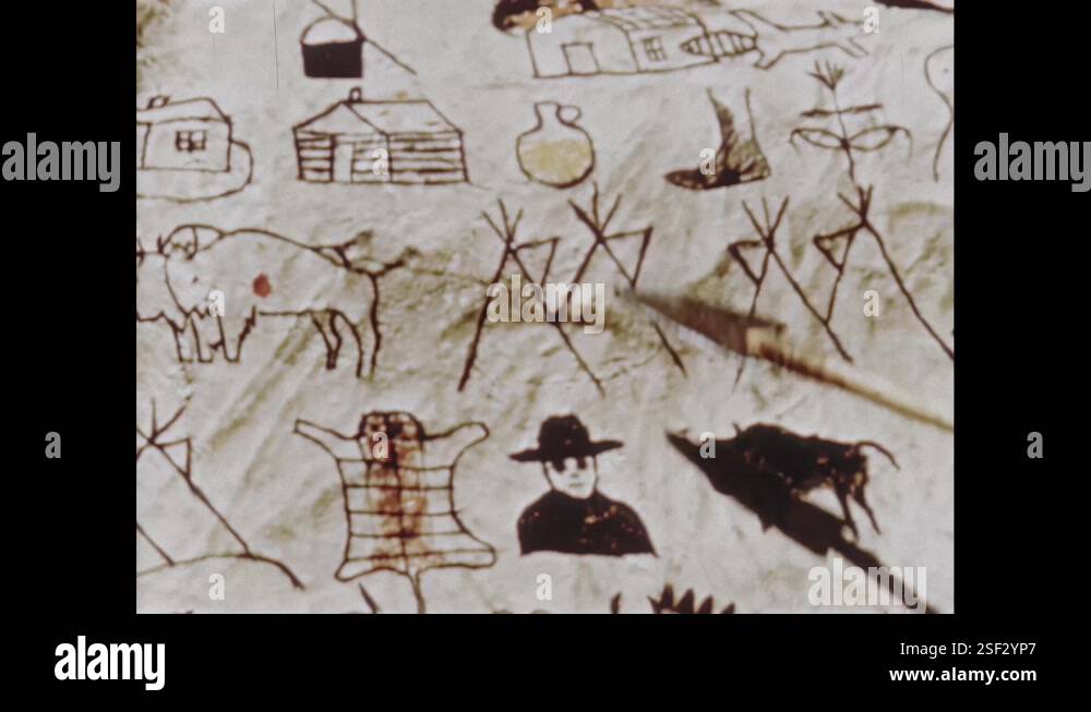 1950s: Man uses arrowhead to point at pictograms painted on hide. Three ...