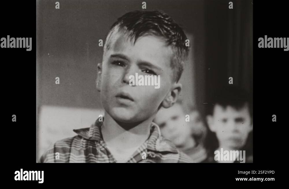 1950s: A boy talking. Another boy answering questions. Teacher at front ...