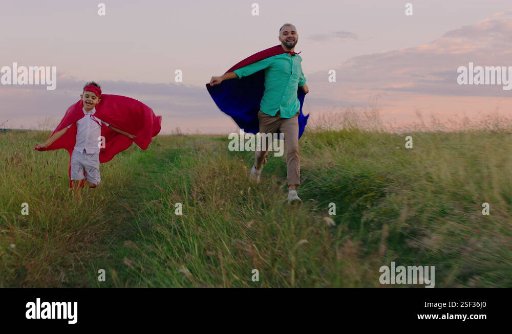 Running fast little boy and his dad they wearing superheroes suits in ...