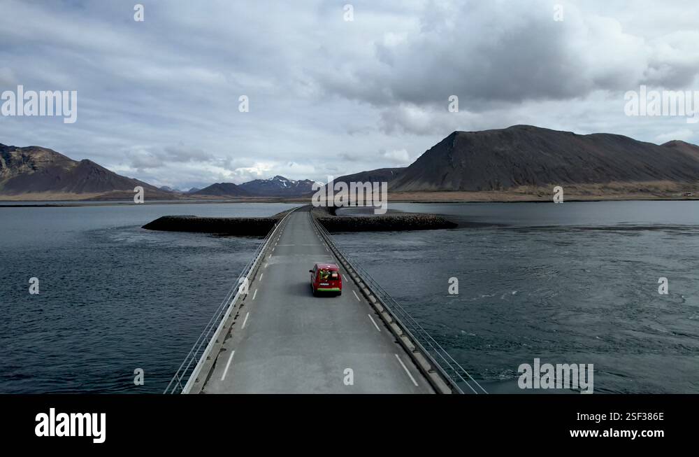Red car driving over sword shaped bridge in Iceland Stock Video Footage ...