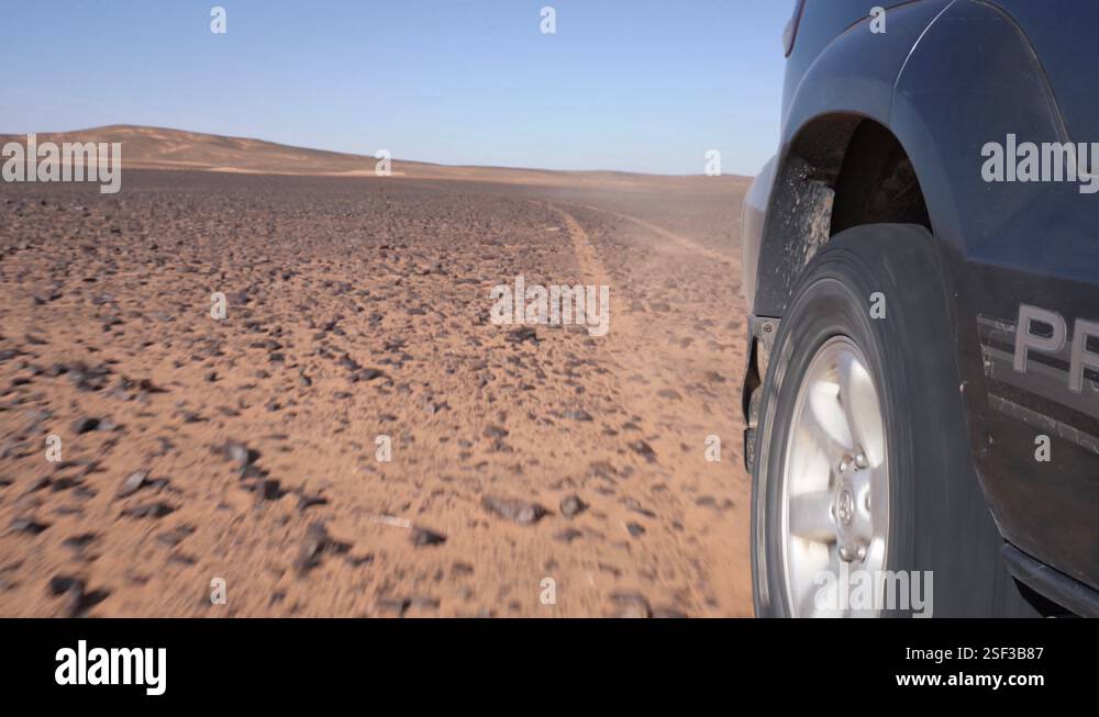 4WD Driving Fast on a Rocky Desert Path in Africa, focus on tyre - Low ...