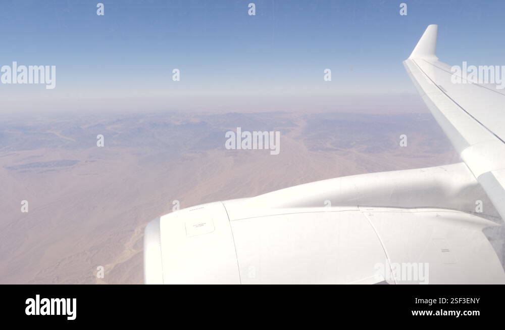 View out of airplane window onto wings and engine. Commercial aircraft ...