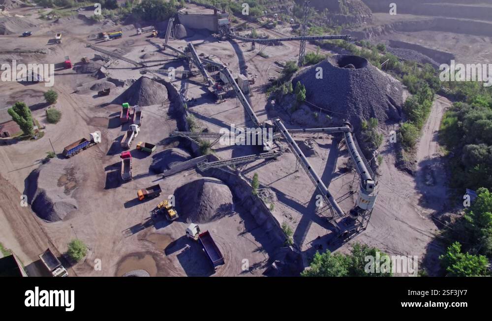 Excavator loading crushed stone into a dump truck in a crushed stone ...