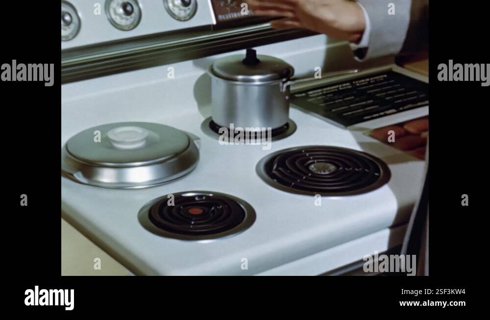 1950s: Hand points to burners on range. Hand removes and replaces ...