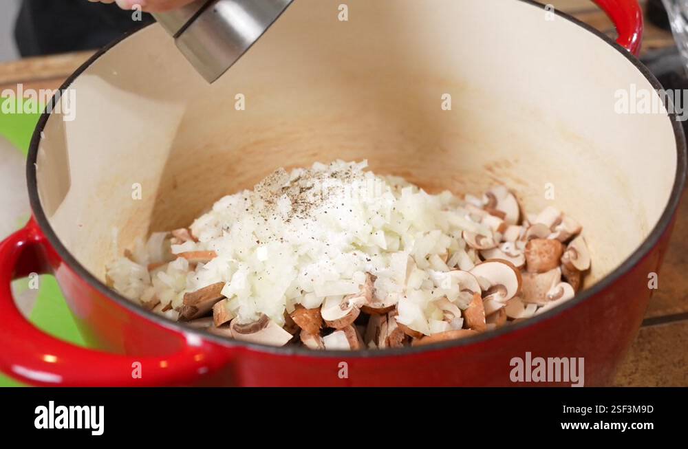 Adding fresh ground pepper to a pot full of sliced mushrooms and diced ...