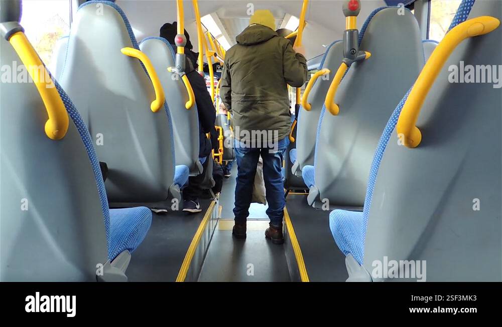 Back view of bus with a man getting off the bus and people using public ...