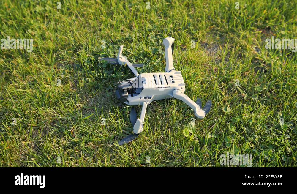 Close up woman's hand picks up a fallen drone from a green lawn Stock ...