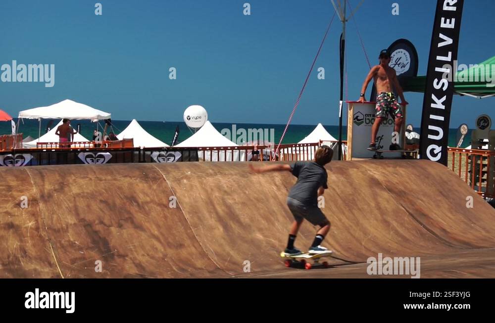 Slow motion view of kids performing with the skate board on a track set ...