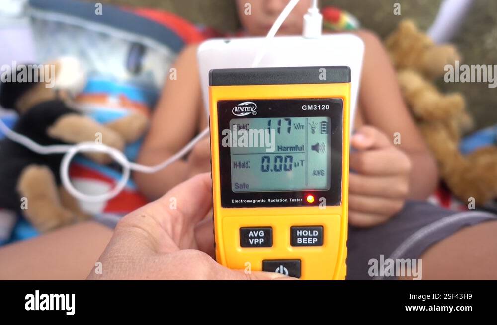 Dosimeter reading in front of a charging pad in hands of child Stock ...