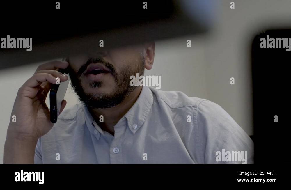 An obscured abstract close up shot of an Indian employee talking on a ...
