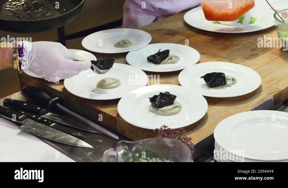 Chefs serve up the dish for the restaurant in the kitchen. Plating and ...