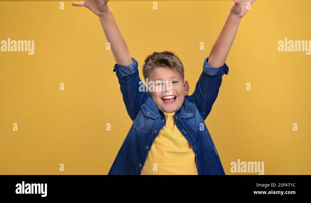 Portrait overjoyed modern teen boy rejoice screaming with raising hands ...