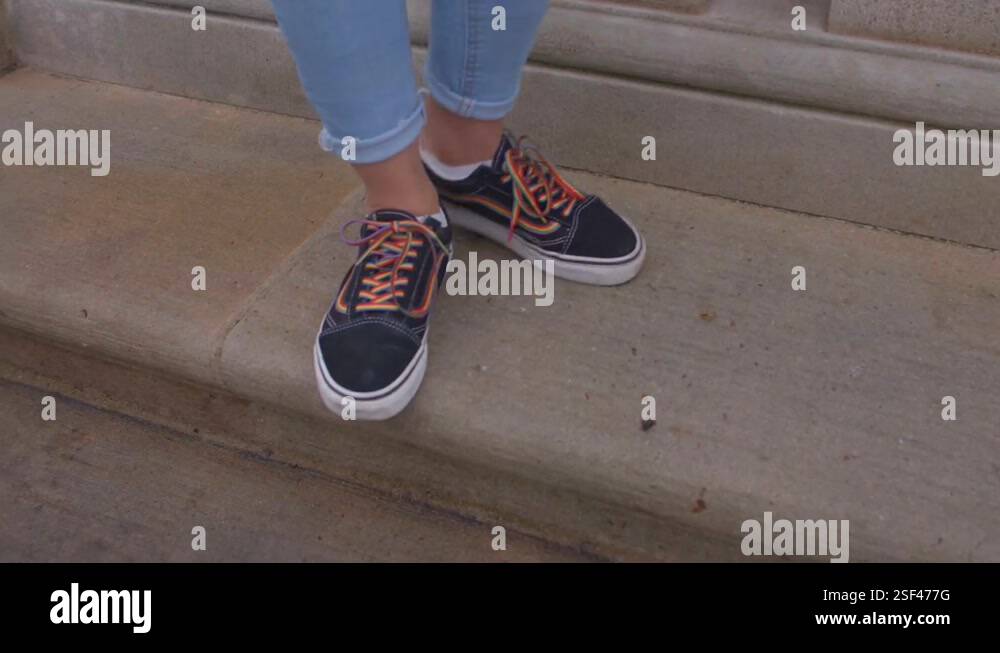 Foot movement on sidewalk and stairs city. One sneakers there rainbow ...