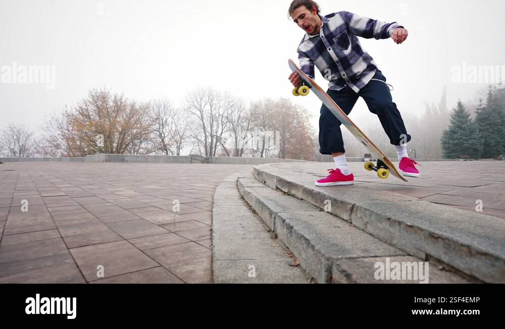 Male skater jumps off the steps and shows a grab in the air. Slow ...