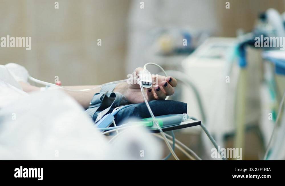 patient's hand under anesthesia in the operating room, a pulse oximeter ...