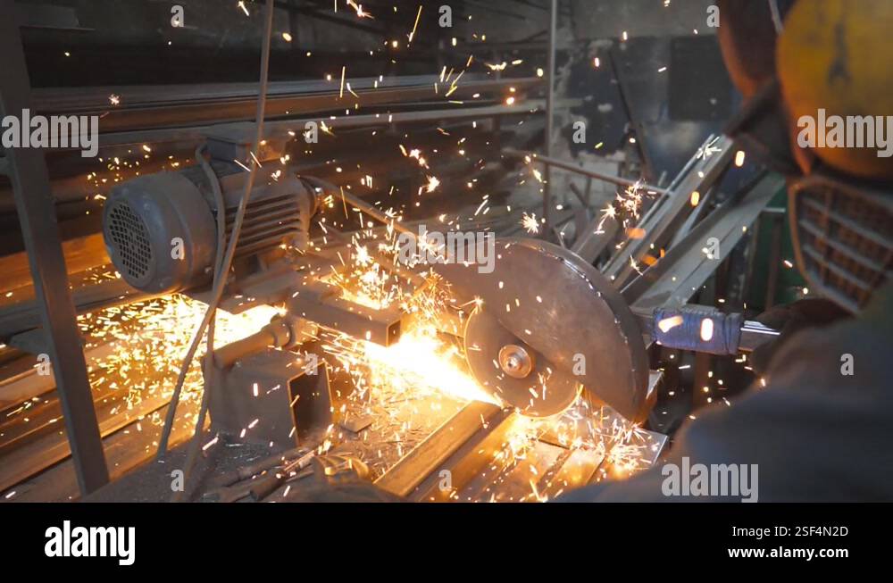 Industrial worker in safety protection wear use saw cutting machine to ...