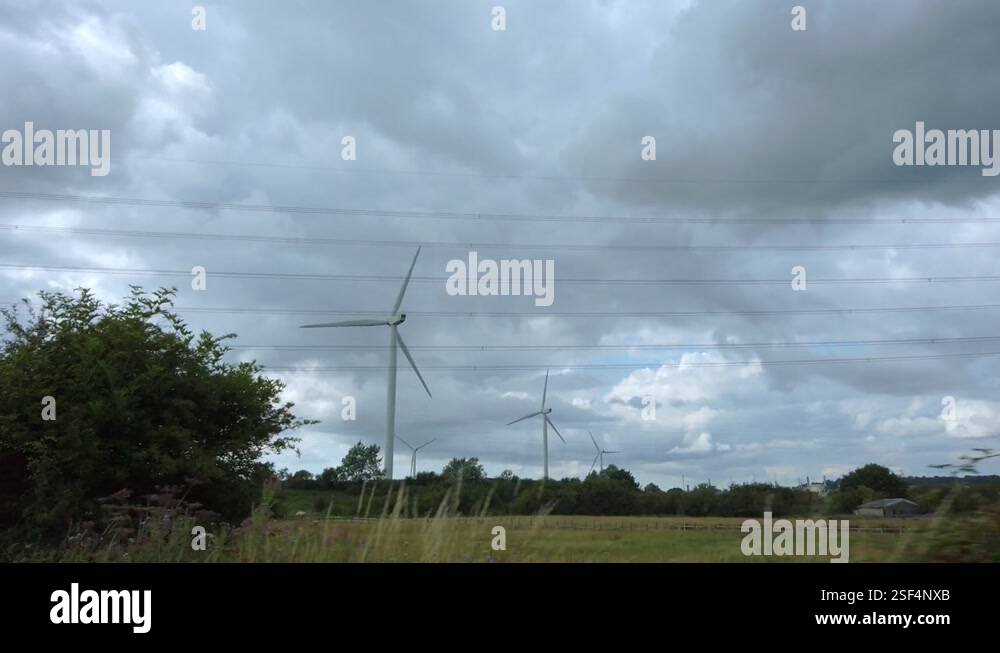 View of wind turbines and electricity pilon on cloudy grey day Stock ...