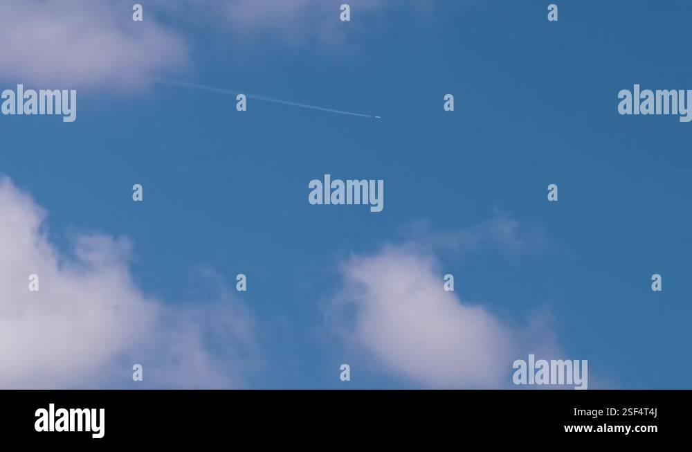 Distant passenger jet plane flying on high altitude on blue sky with ...