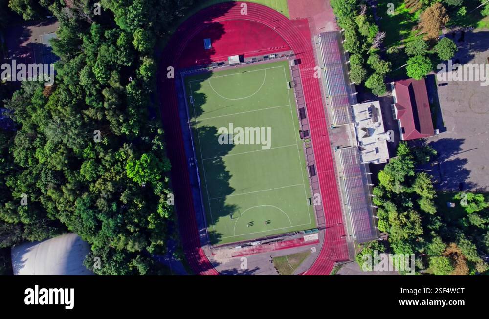 Buildings with street in small town with empty football soccer field ...