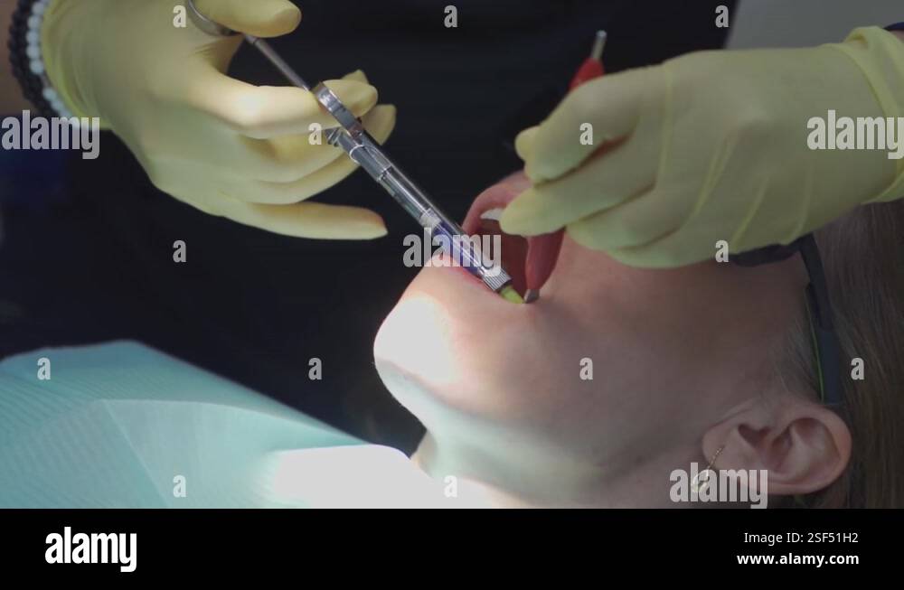 real. dentist injects an anesthetic into patient before tooth ...
