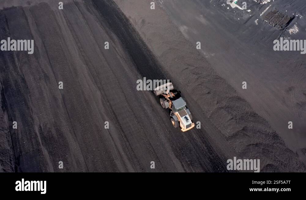 Aerial tracking shot of Digger working on coal mining field and Stock ...