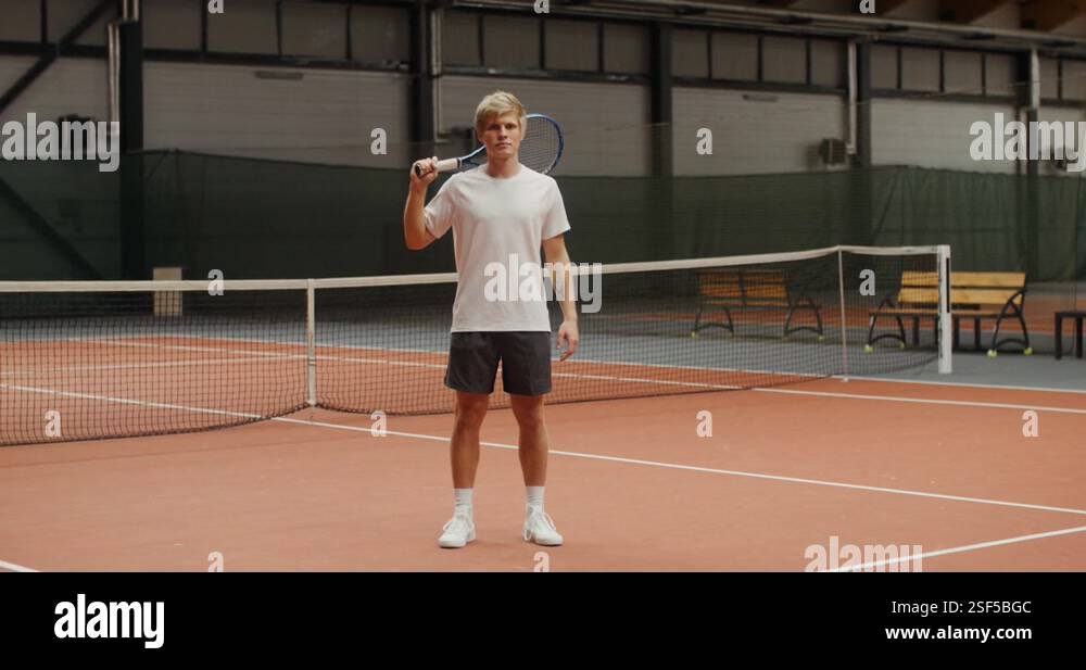 A tennis player throws a tennis racket behind his head, looking at the ...