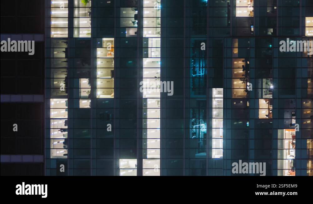 Vertical time lapse office windows lights in business center building ...