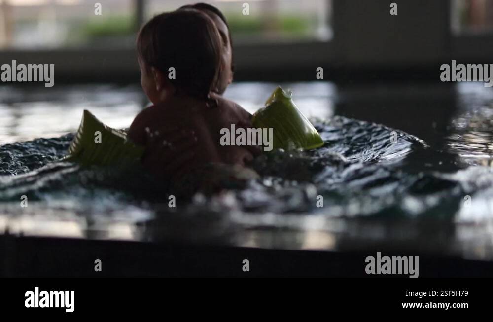 Toddler child playing with father at swimming pool. baby diving into ...
