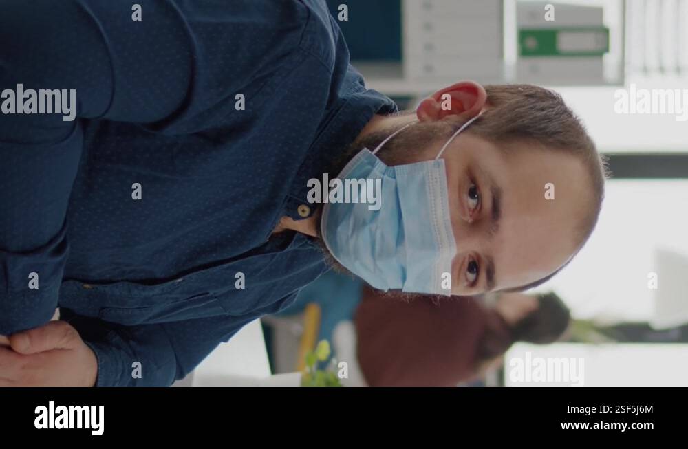 Video vertical: Employee with protection mask sitting on wheelchair in front of Stock Video ...