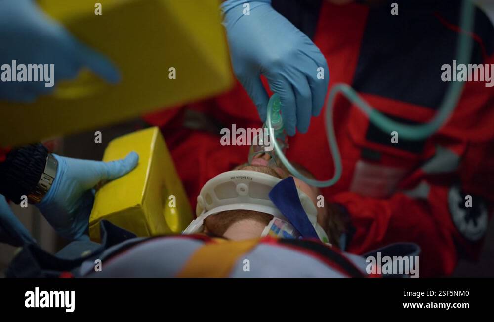 Paramedics providing first aid for man. Doctors holding oxygen mask on ...
