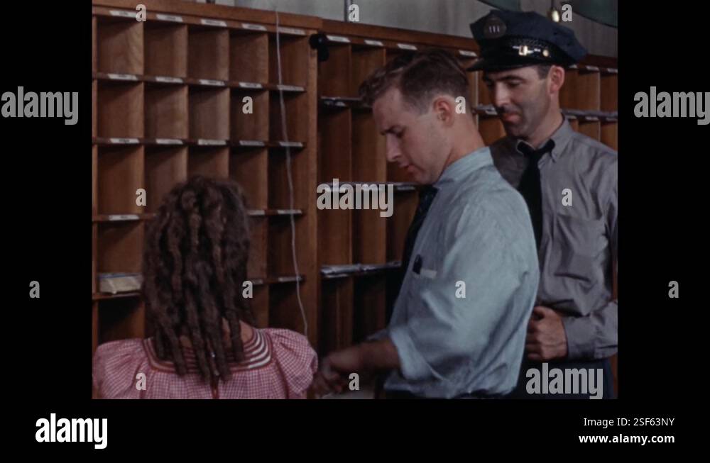 1960s: Man in post office sorts mail into boxes. Girl, woman and mail ...