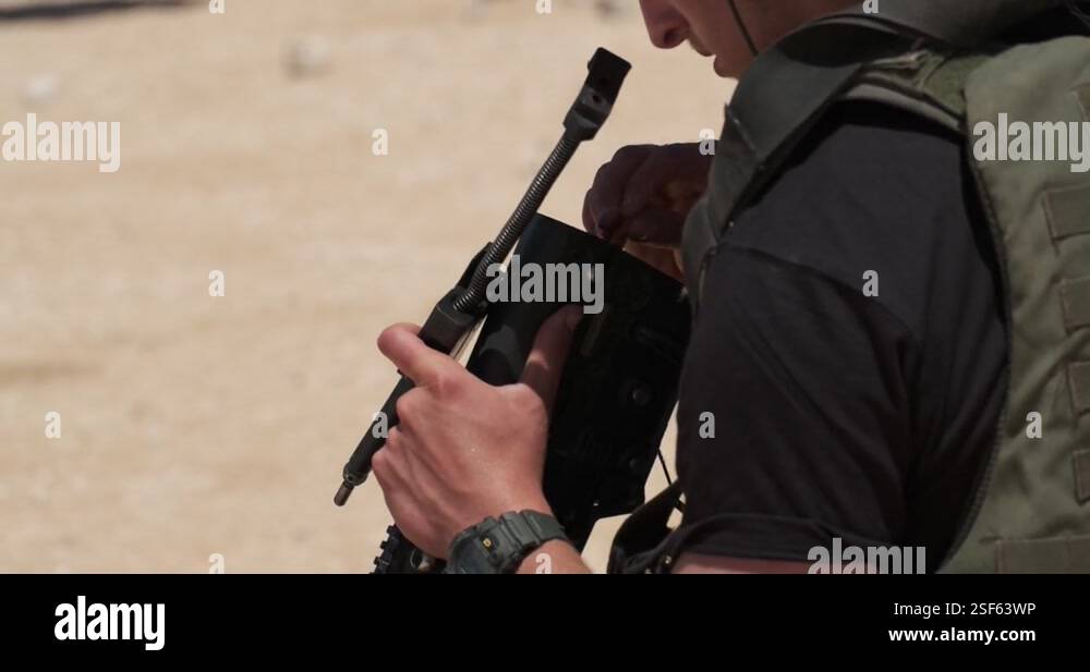 A soldier in training puts his weapon back together after disarming it ...